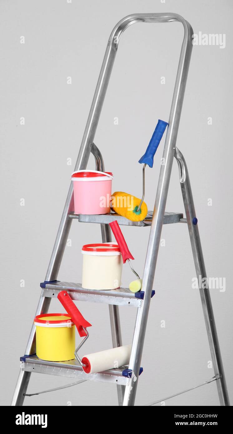 Metal ladder and paint in room Stock Photo - Alamy