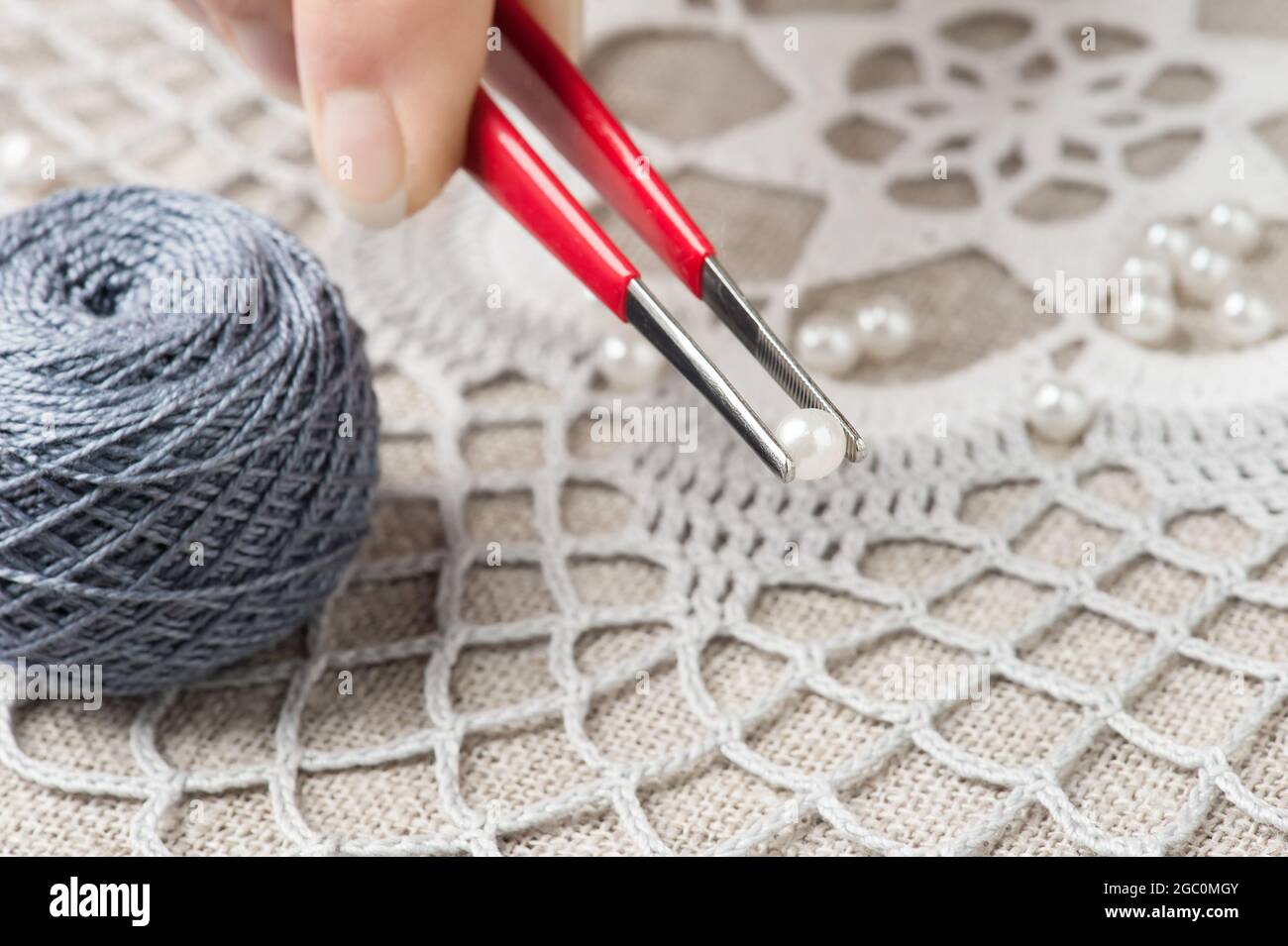 Closeup of female hands holding pearl and grey dream catcher background ...