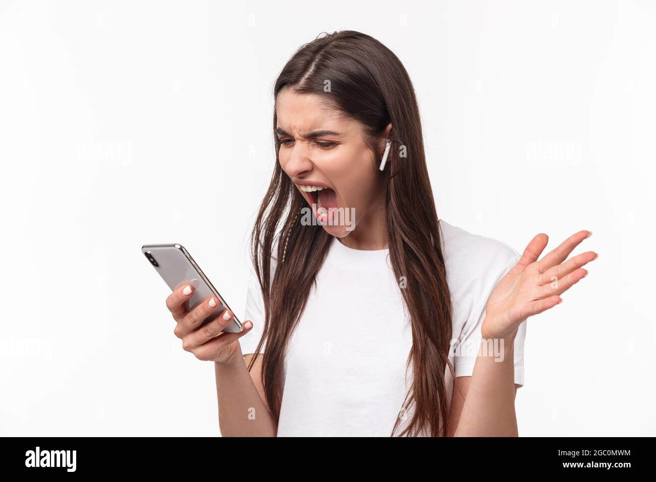 Close-up portrait of pissed-off aggressive and angry young brunette ...