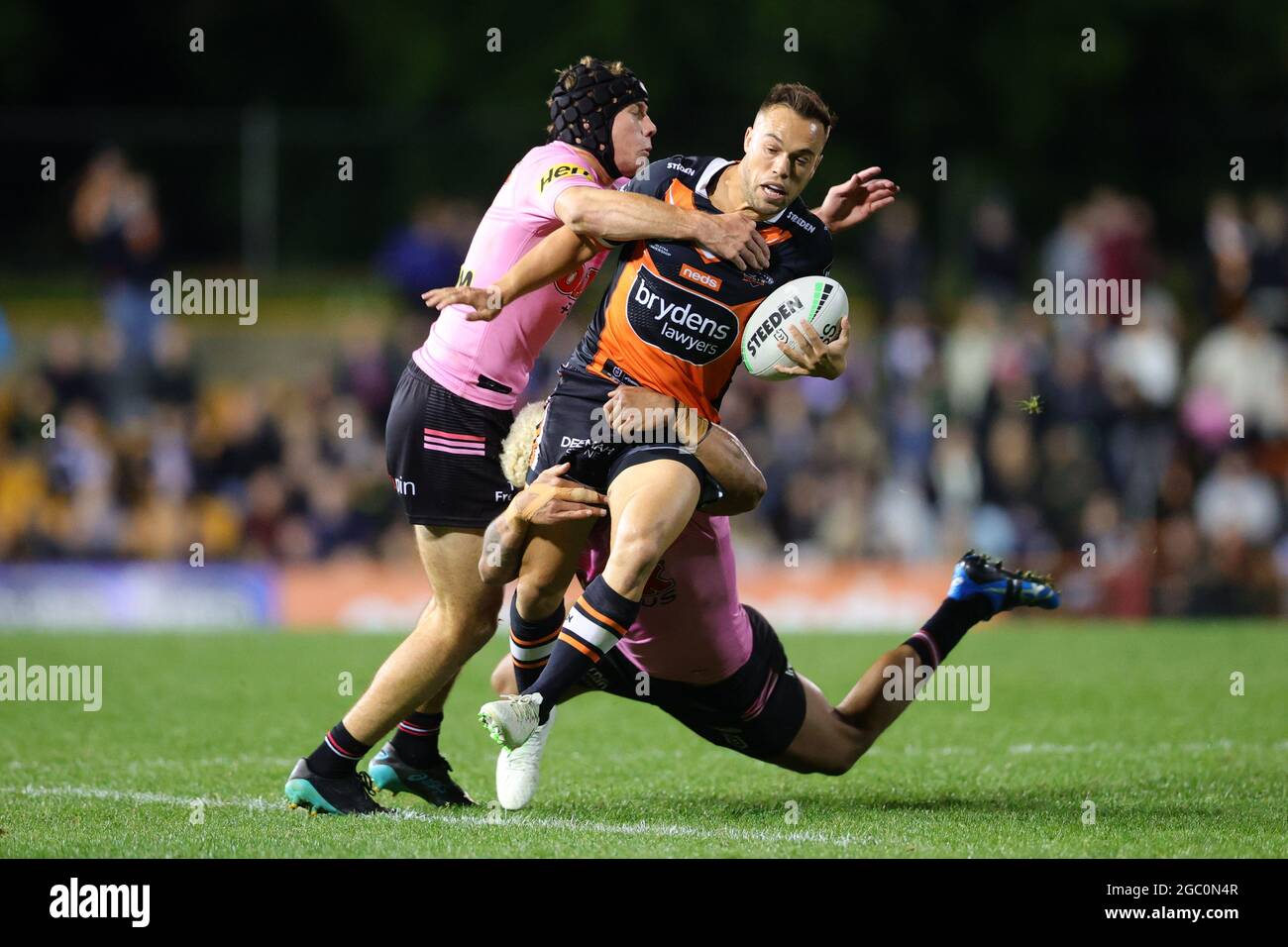 Luke Brooks of the Tigers is tackled Credit: Pete Dovgan/Speed Media ...