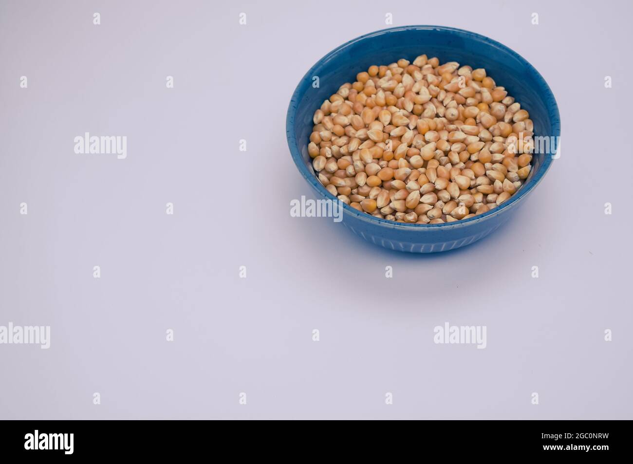 High angle shot of corn grains on a bowl isolated on light gray ...