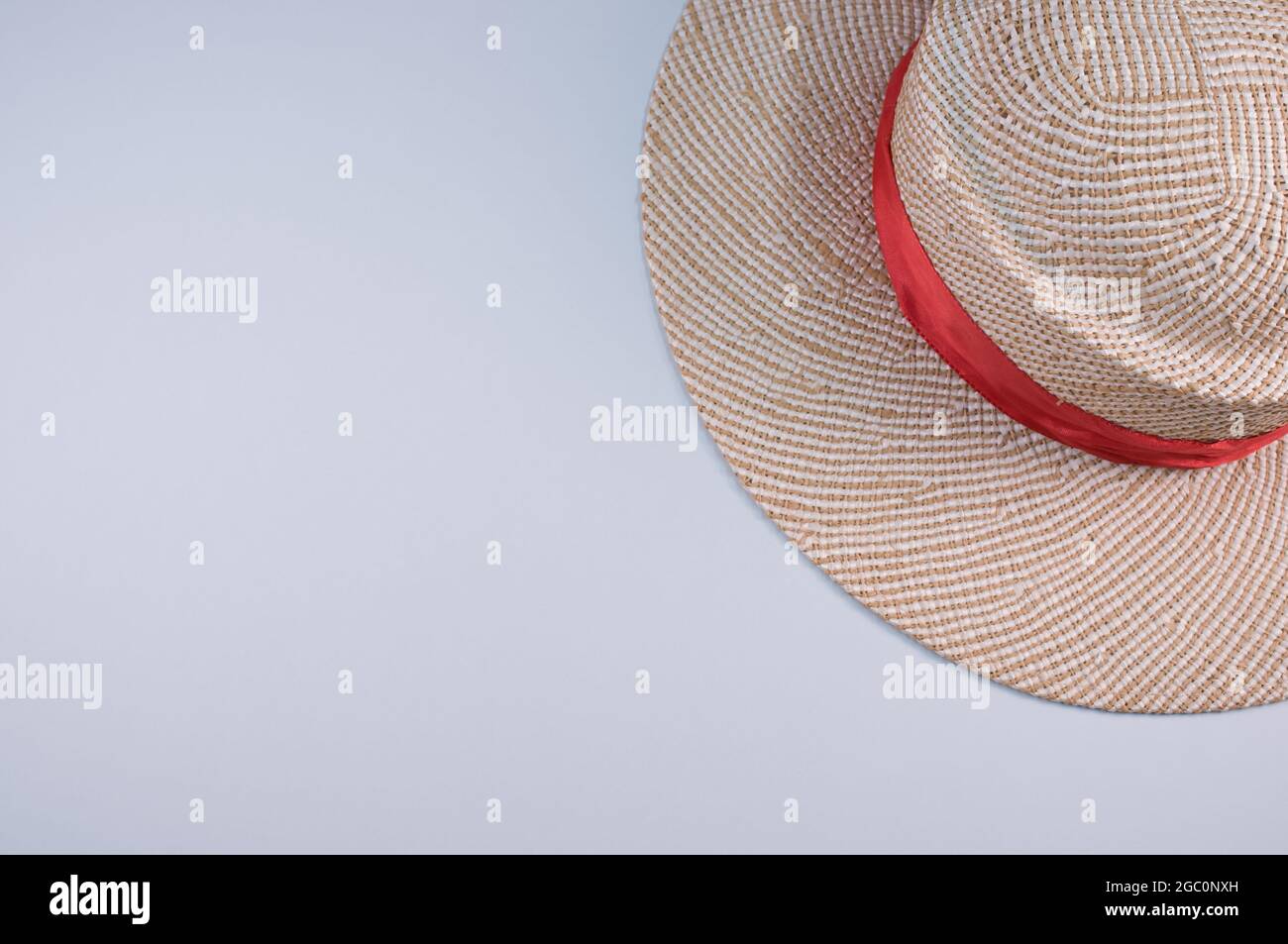 Top view of a straw hat with red ribbon isolated on a light gray ...