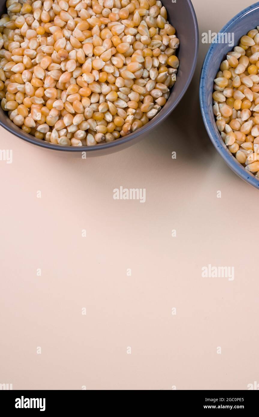 Vertical shot of corn grains on a bowl isolated on light brown ...