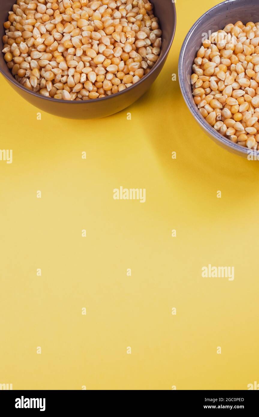 Vertical shot of corn grains on bowl isolated on yellow background ...