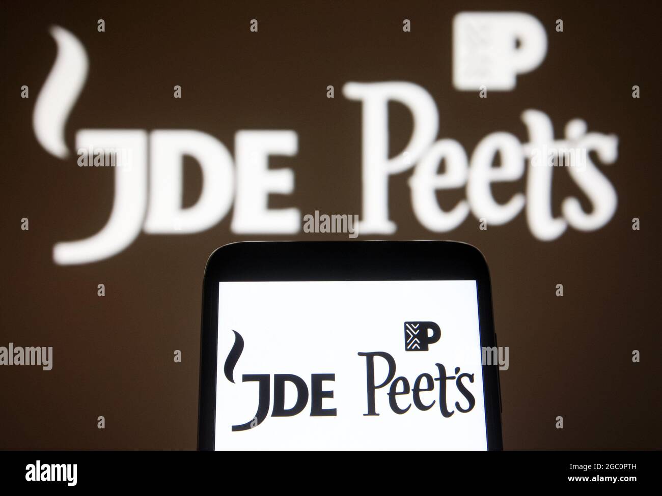 In this photo illustration a JDE Peet's logo is seen on a smartphone and a pc screen. (Photo by ...