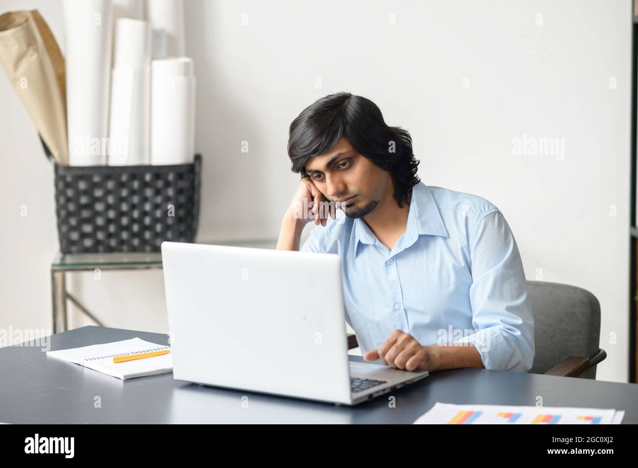 Tired indian male office employee staring at the laptop screen, feels ...