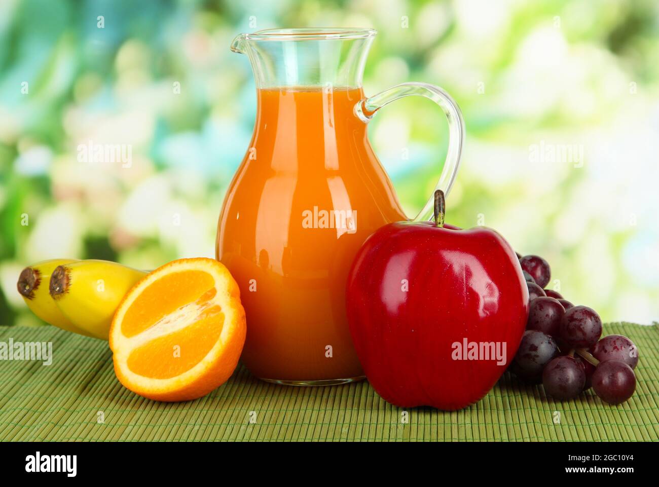 Orange juice in pitcher on table on bright background Stock Photo - Alamy