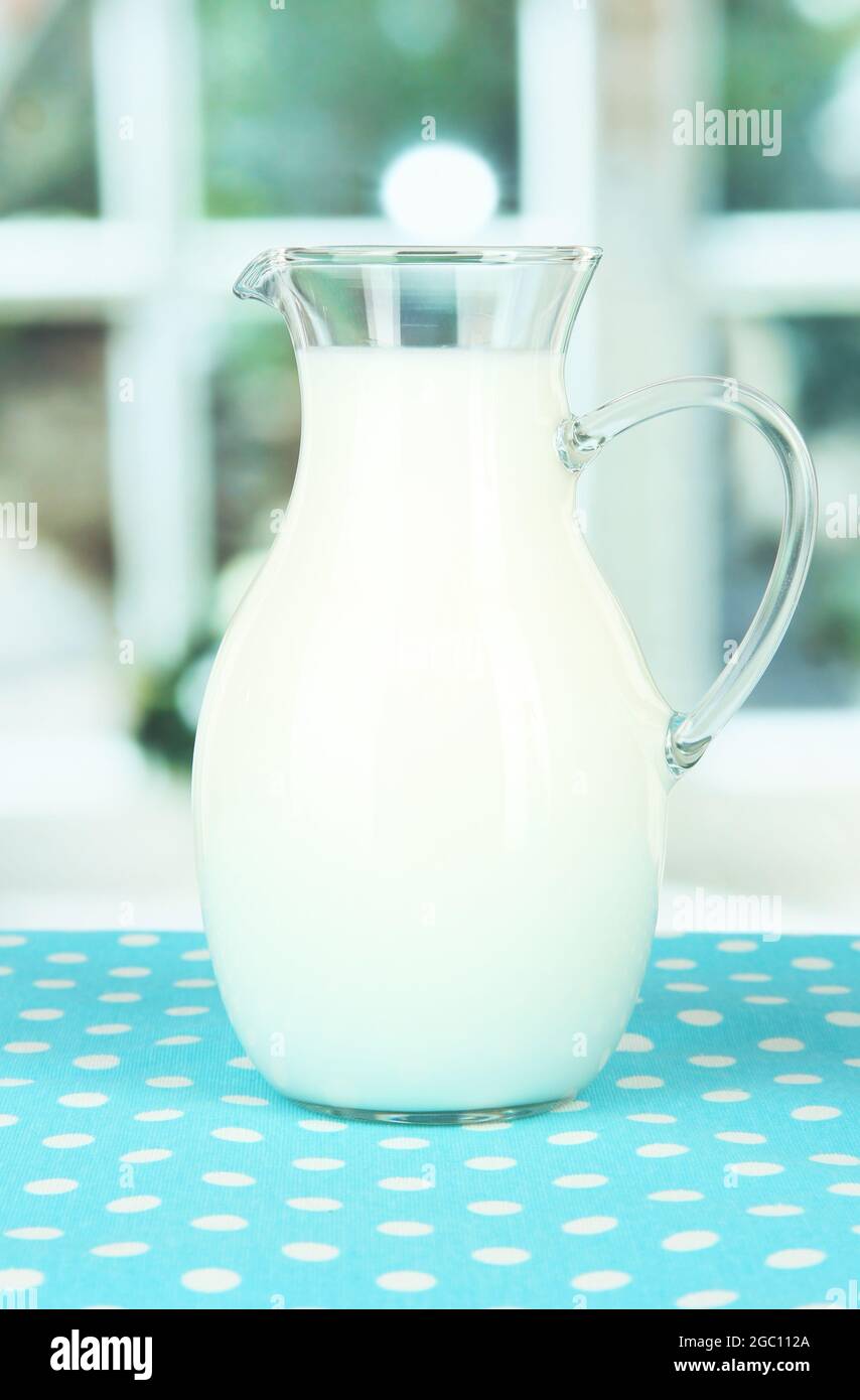 Pitcher of milk on table in room Stock Photo - Alamy