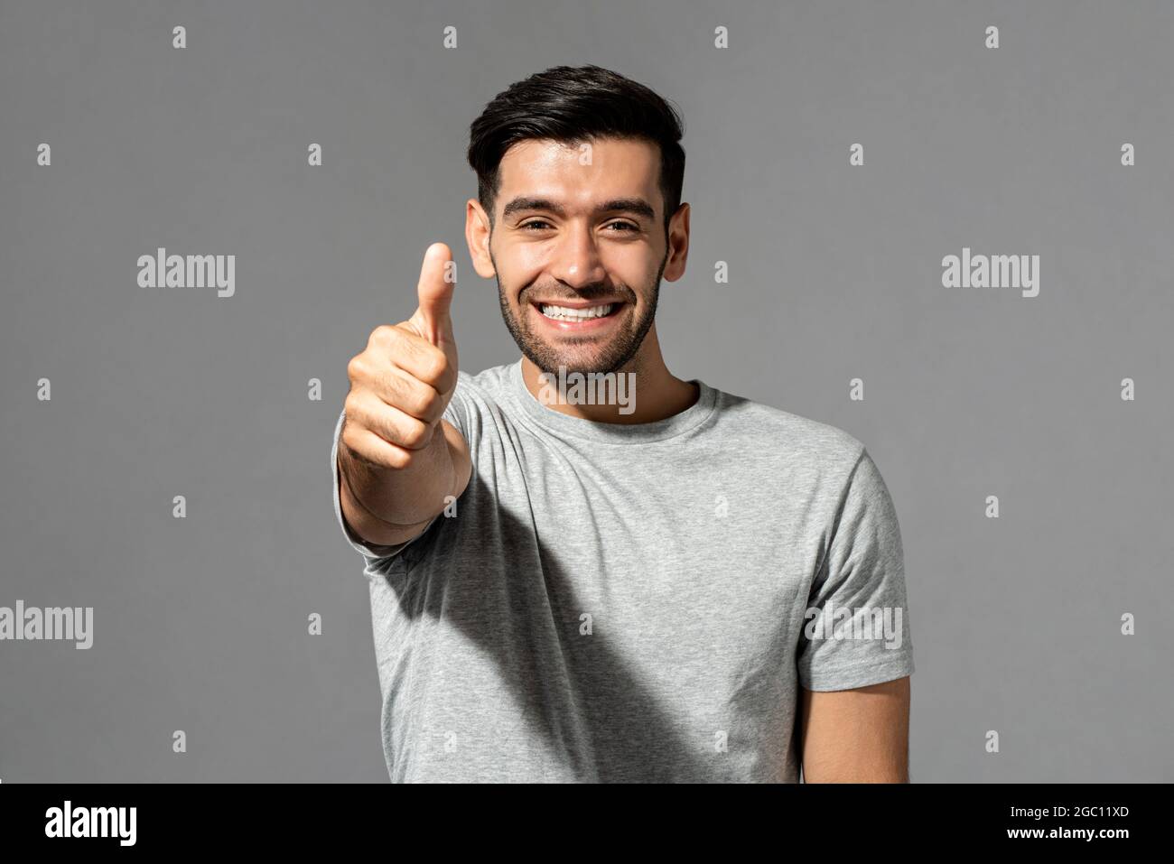 Smiling happy young Caucasian millennial man doing thumbs up gesture in ...