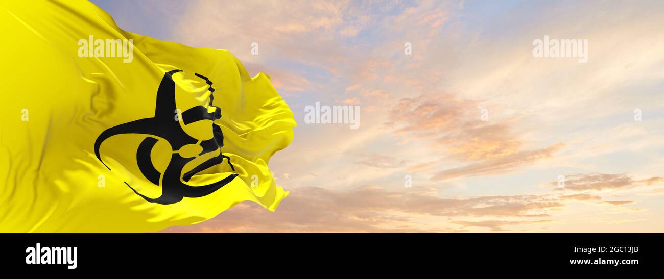 yellow flag of biohazard waving in wind on flagpoles against sky with ...