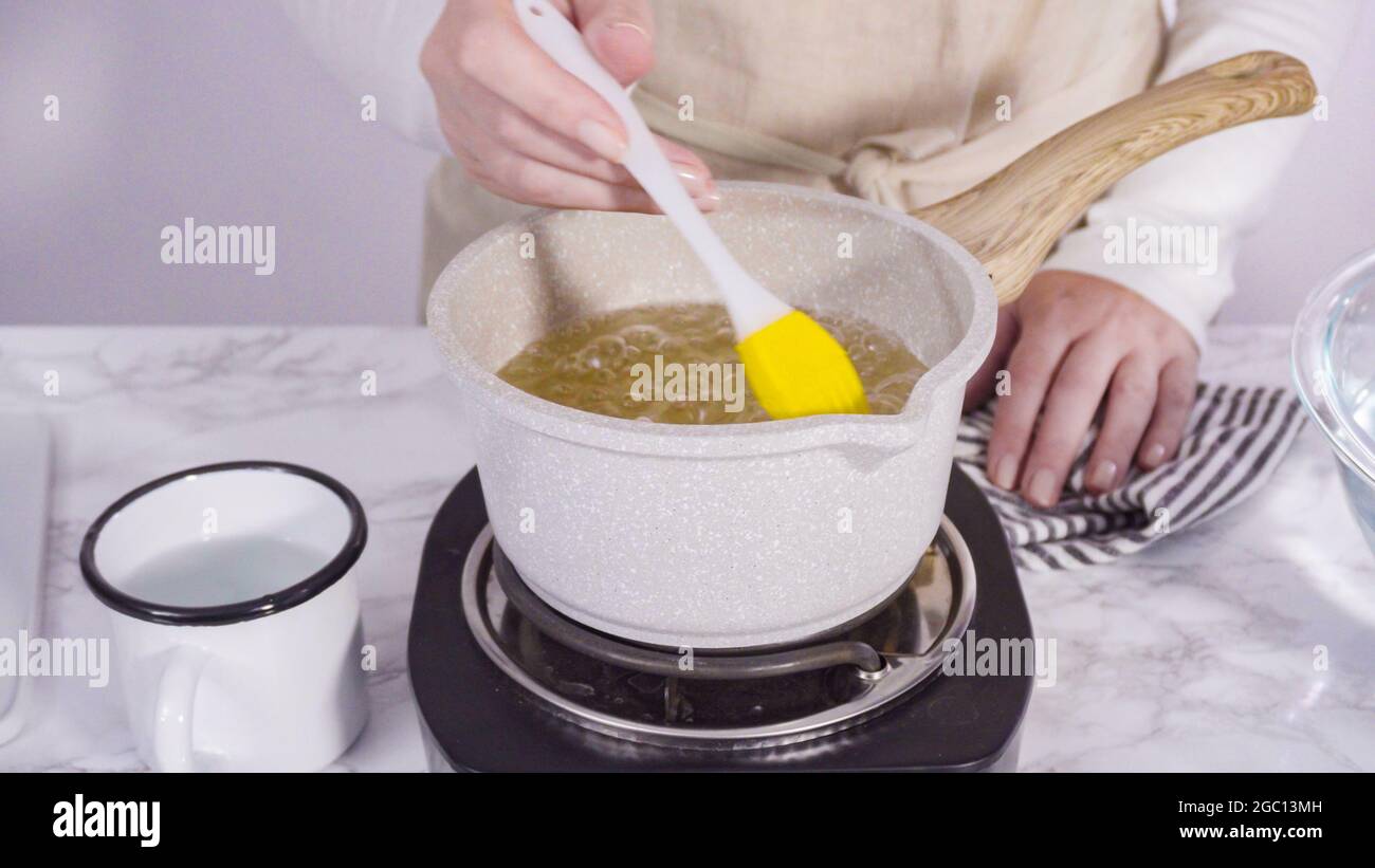 Step by step. Caramelizing sugar in a small cooking pot over the small ...