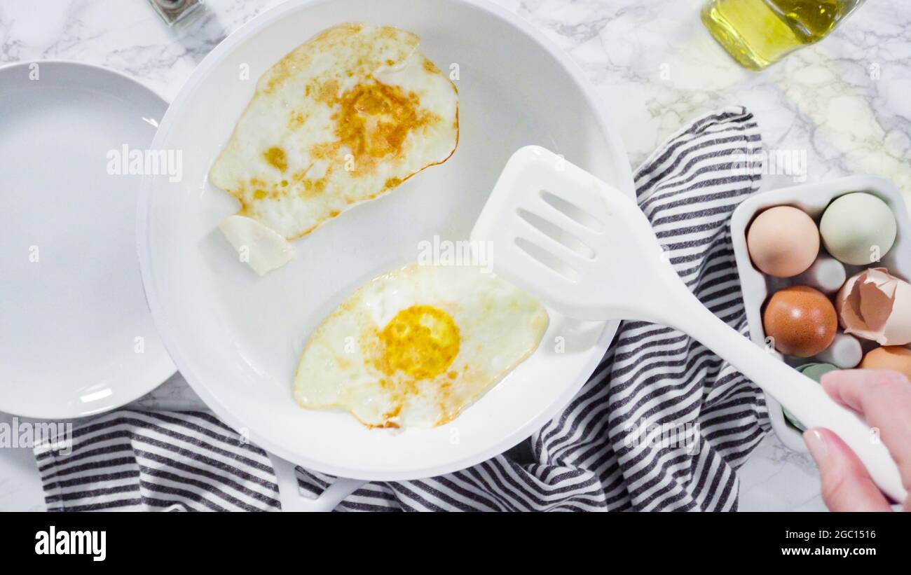Flat lay. Frying farm fresh eggs in a white skillet Stock Photo - Alamy