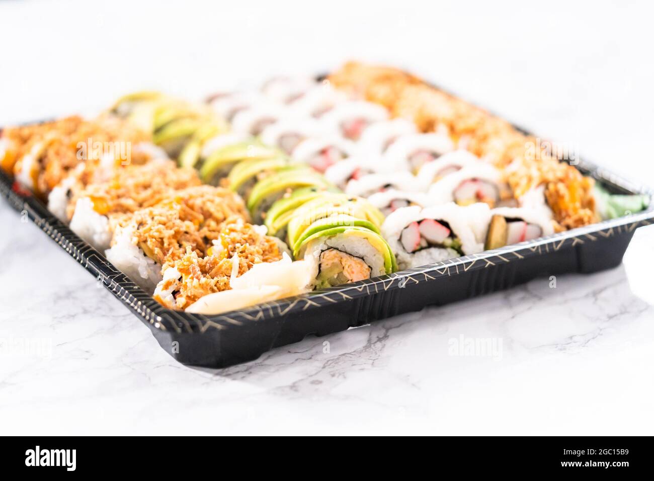 Pre-packaged variety of sushi and sushi rolls in a plastic tray Stock ...