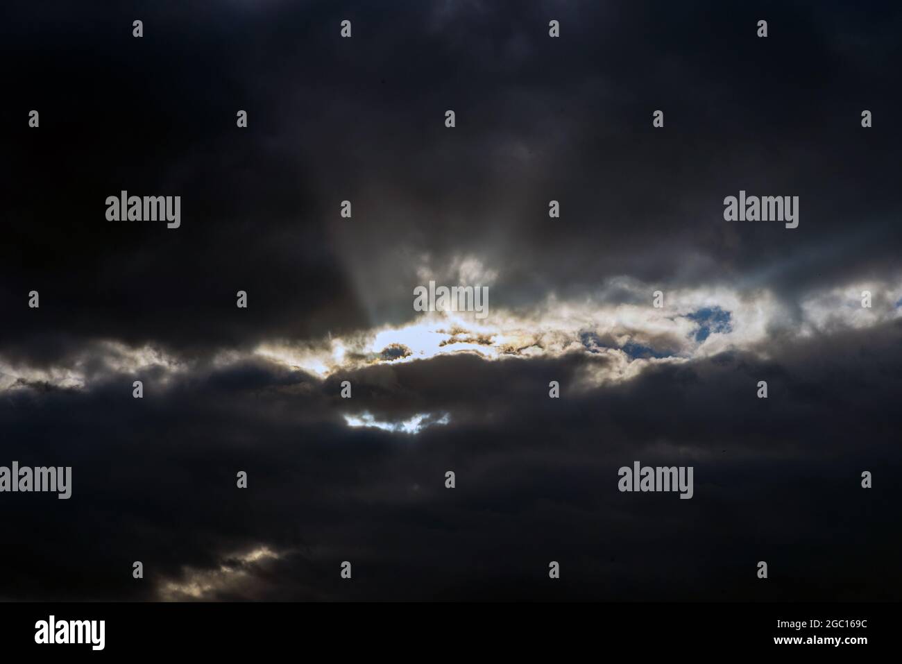 Rays of light shining throug dark clouds.Beautiful dramatic sky with ...