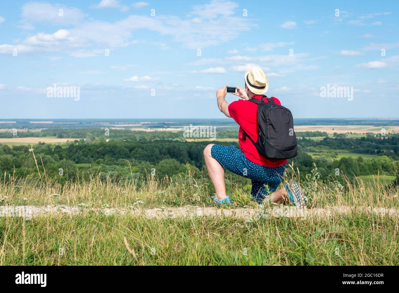 Young male tourist photographs with telephone camera the landscape of ...