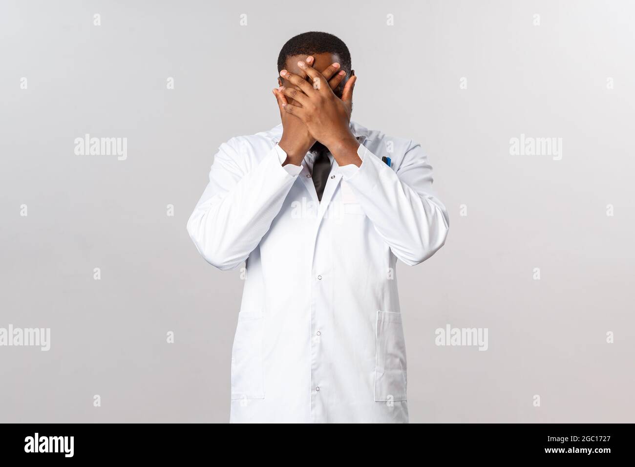 Annoyed, pissed-off african-american male doctor trying avoid annoying ...