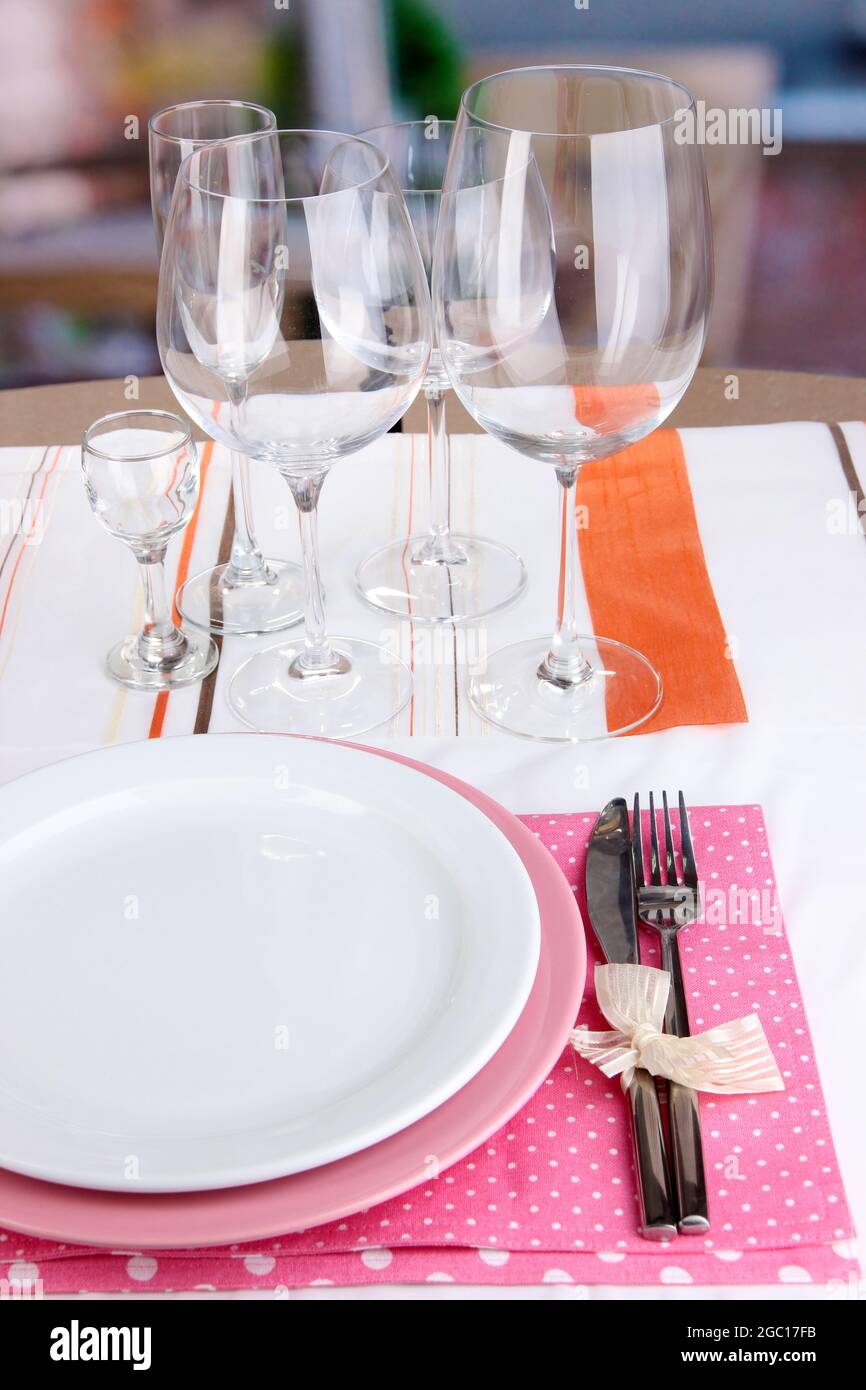 Table setting with glasses for different drinks on table on room ...