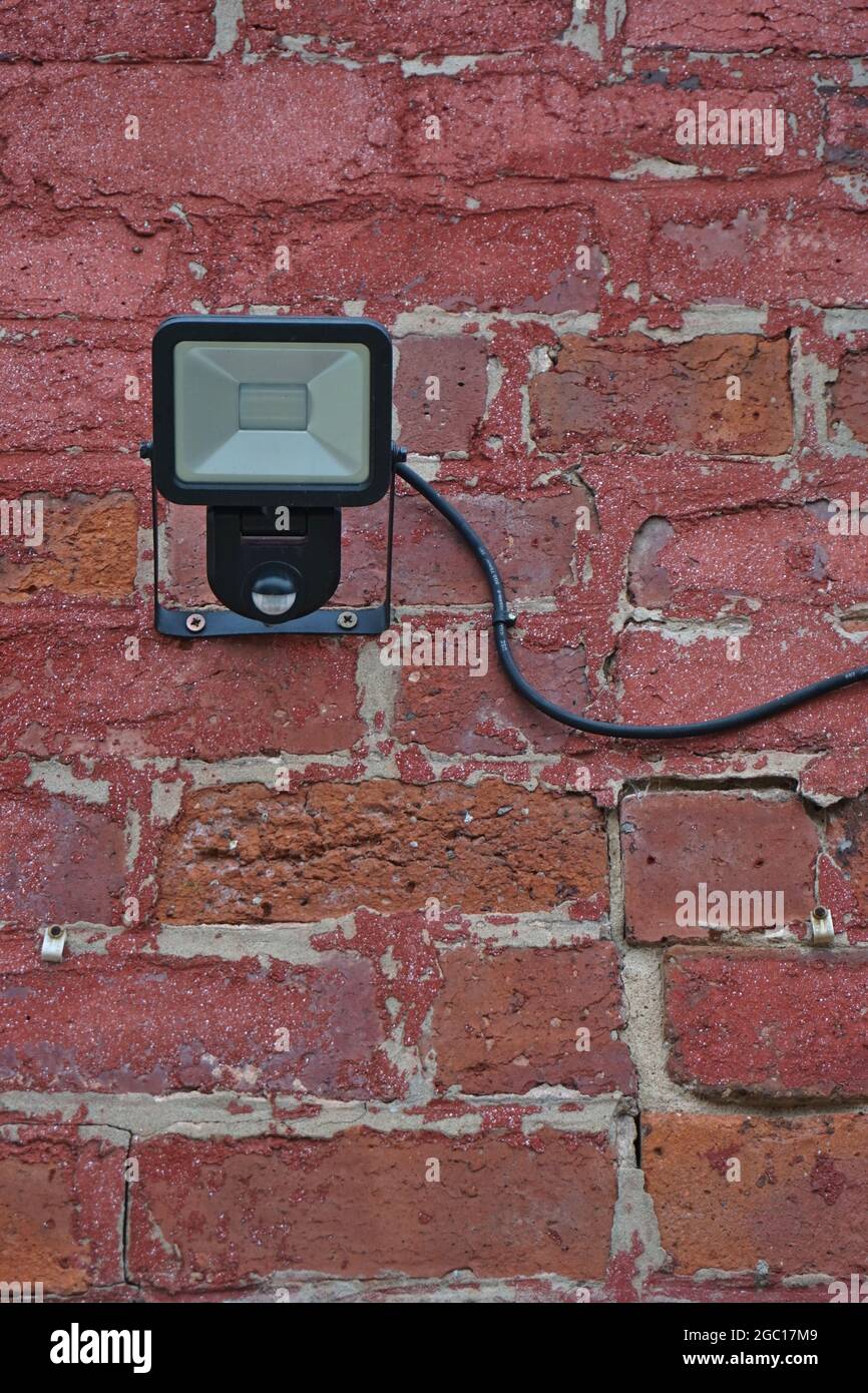 Light with automatic motion sensor on a red brick wall Stock Photo - Alamy