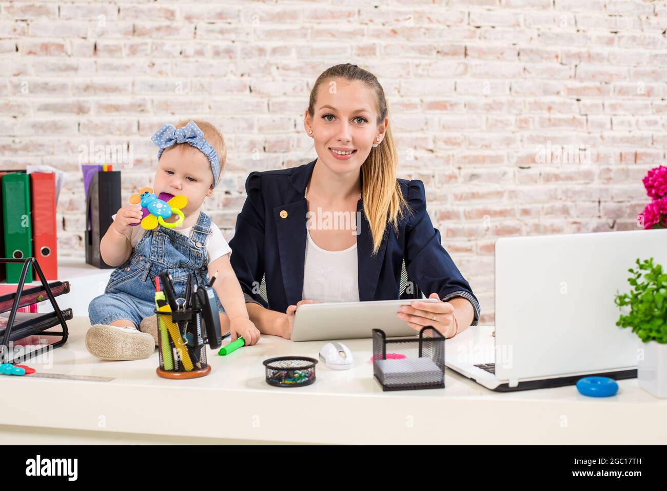 Mom and businesswoman working with laptop computer at home and playing ...