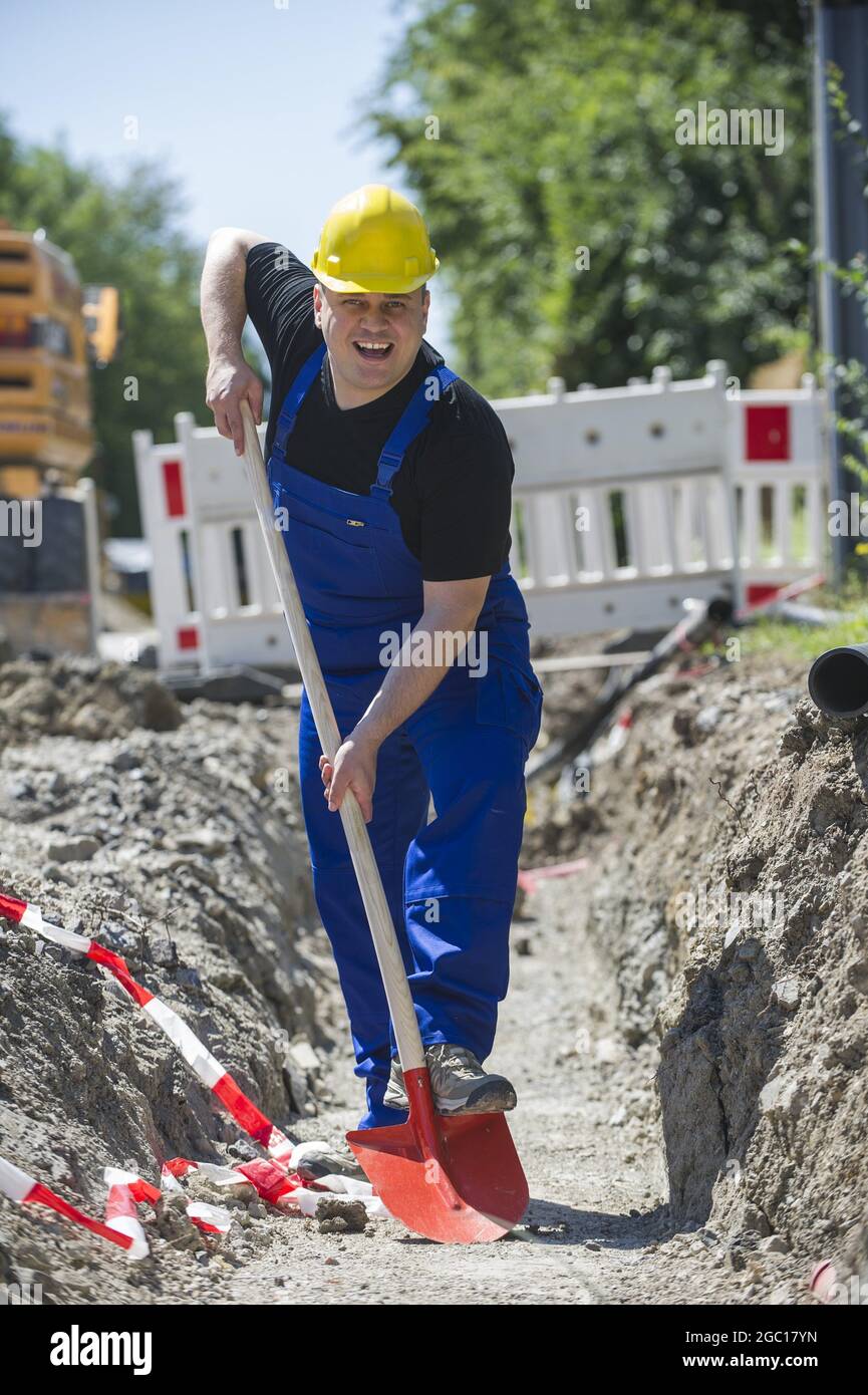 construction worker with shovel in an utility trench Stock Photo - Alamy