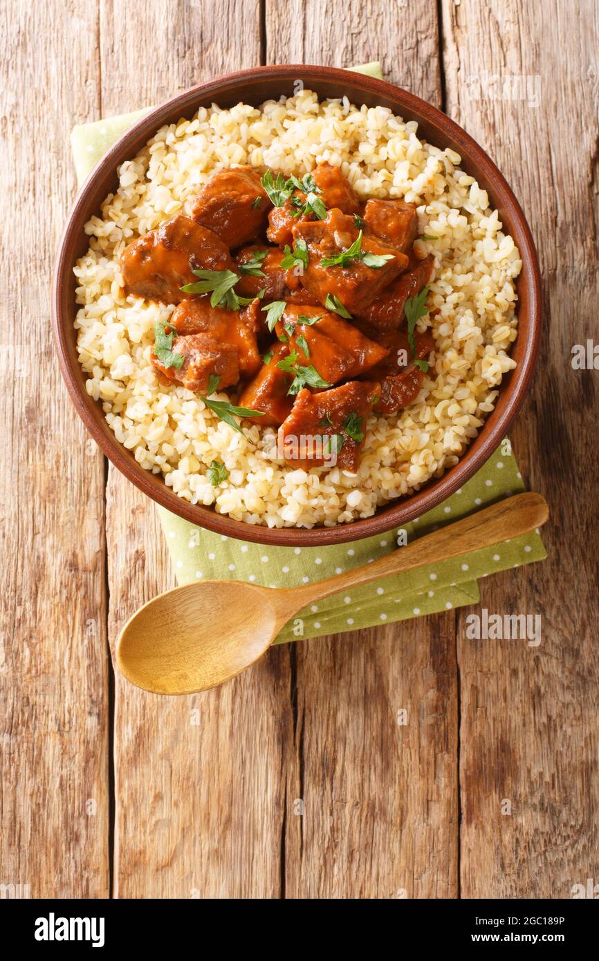 Afelia Cypriot Braised Pork with bulgur pilaf closeup in the plate on ...