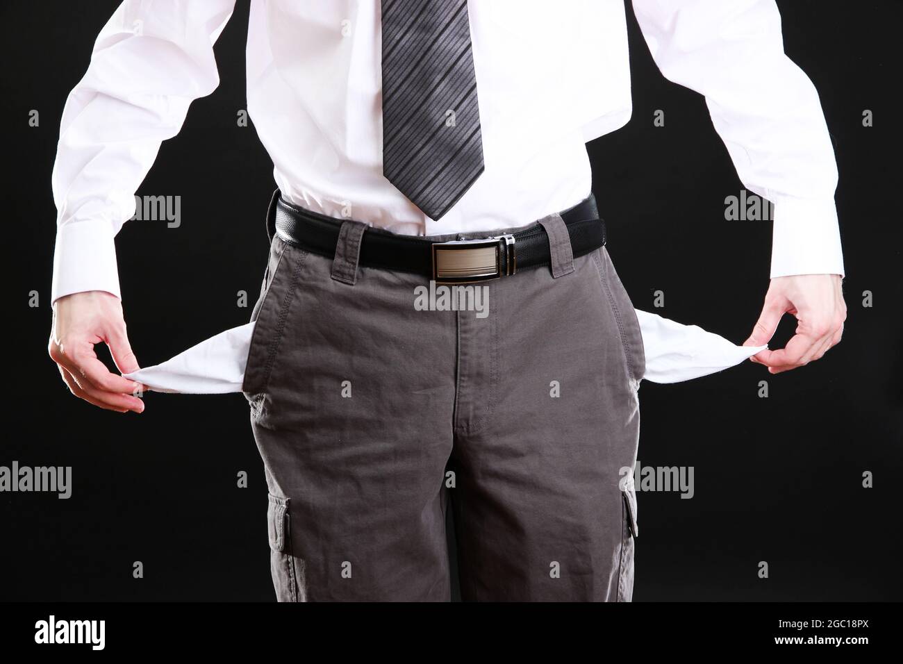 Business man showing his empty pockets, on black background Stock Photo ...