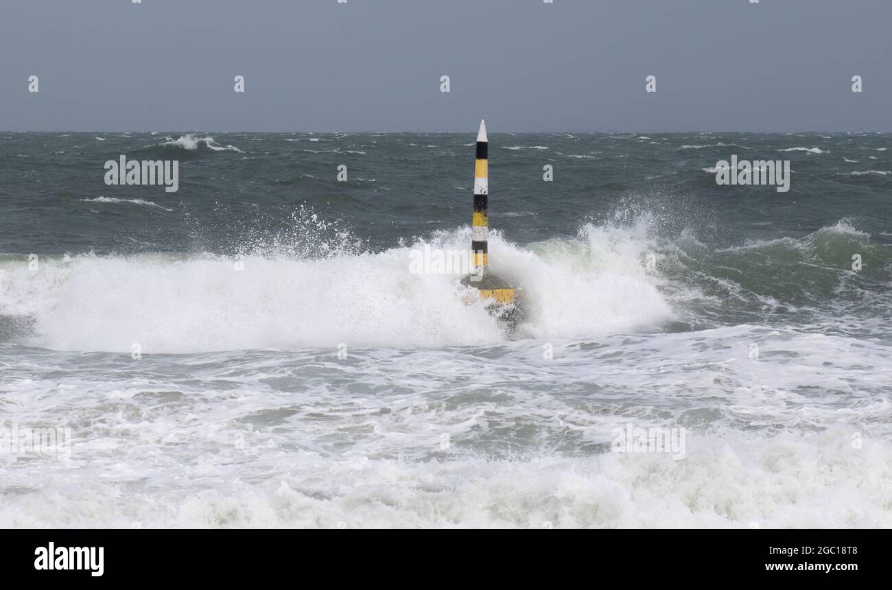 Yellow Back and White Pylon surrounded by a stormy sea Stock Photo - Alamy