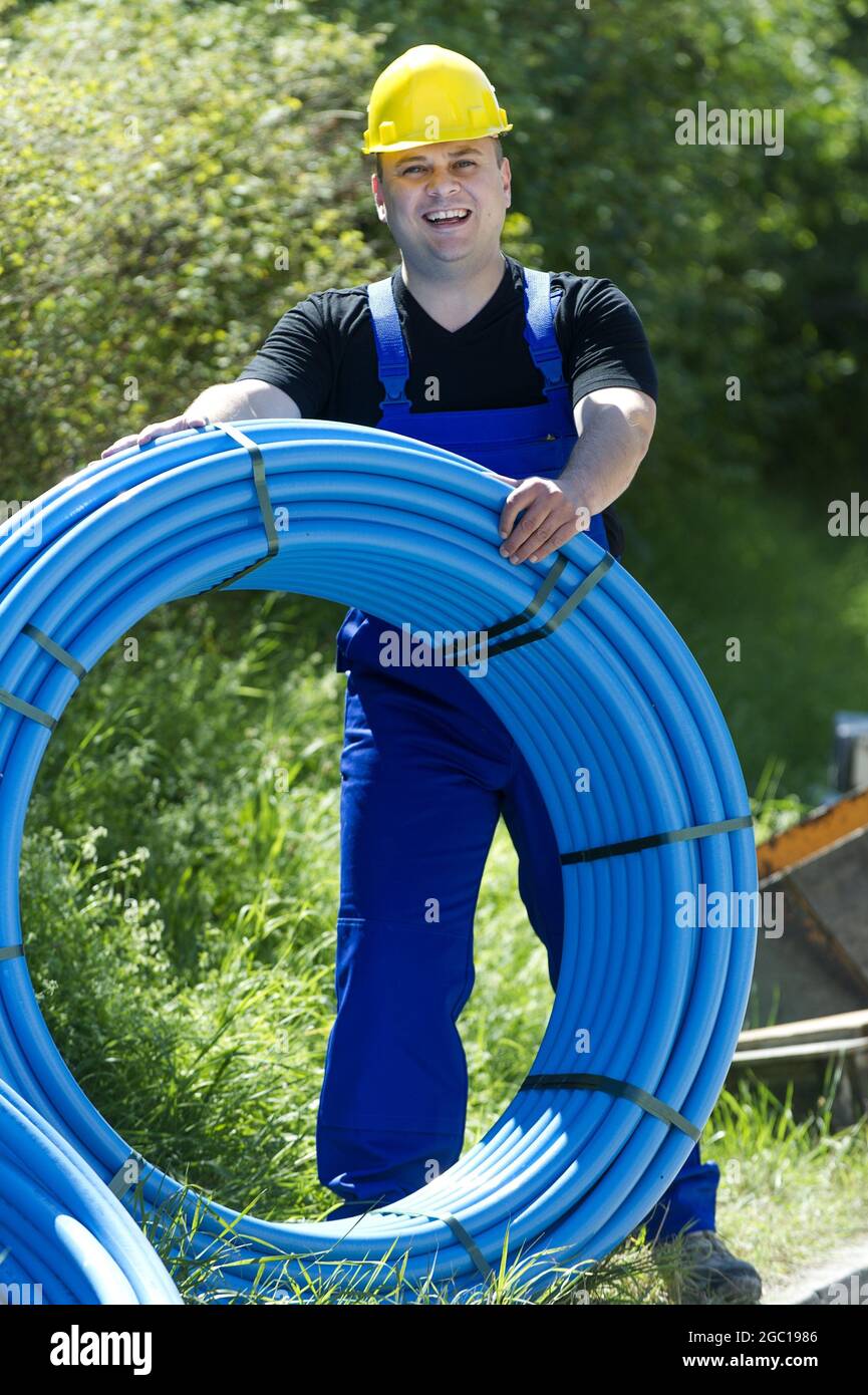 construction worker with a supply pipe Stock Photo - Alamy