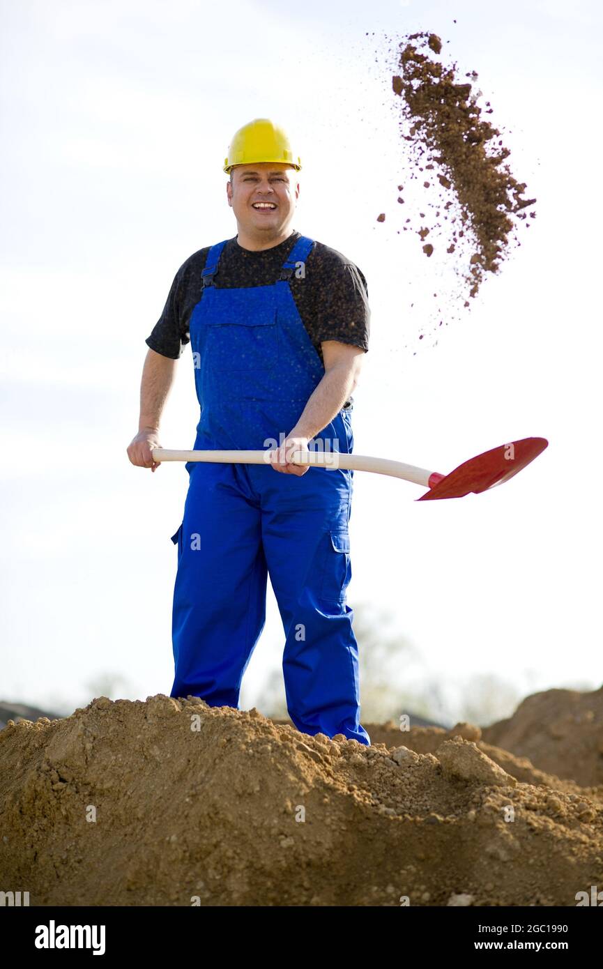 construction worker shoveling sand Stock Photo - Alamy