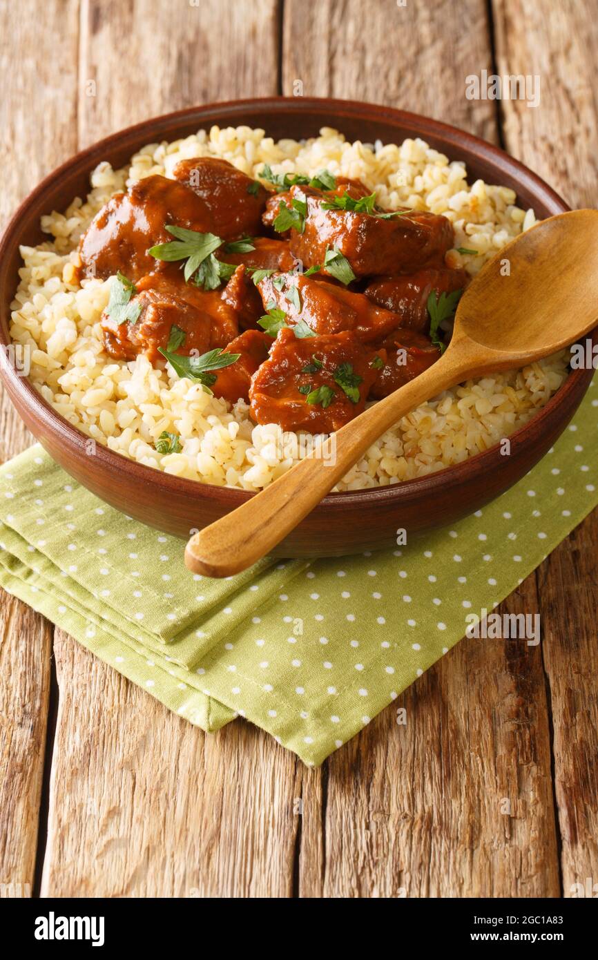 Afelia Cypriot Braised Pork with bulgur pilaf closeup in the plate on ...