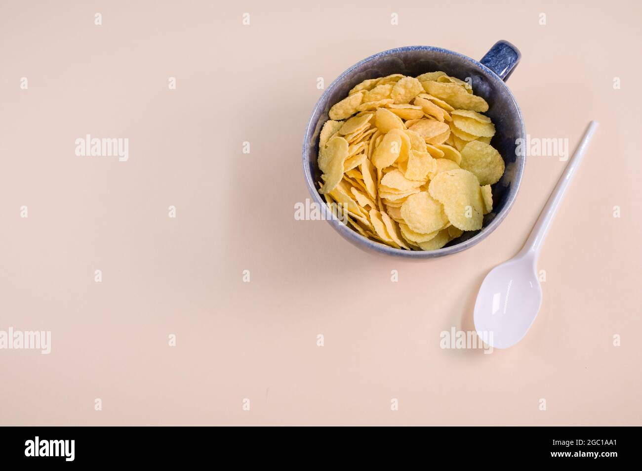Top view of corn flakes on a cup with plastic spoon isolated on brown ...