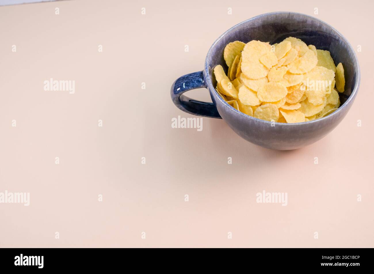 High angle shot of corn flakes on a cup isolated on light brown ...