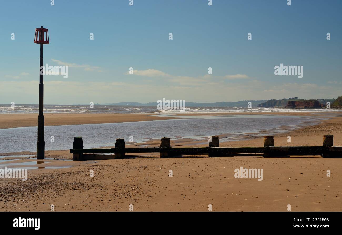 A groyne and marker beacon on Dawlish Warren beach at low tide Stock ...