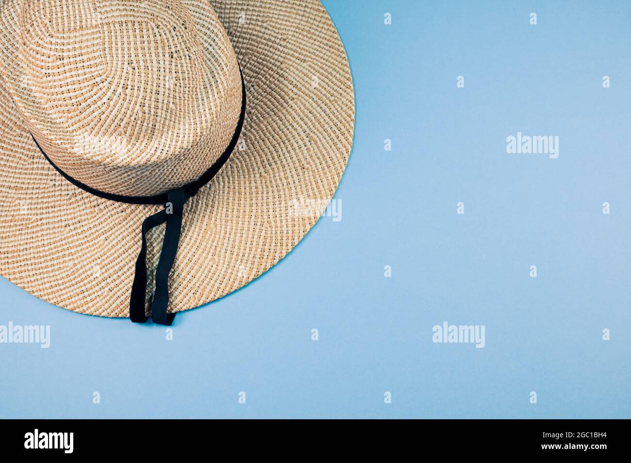 Top of a straw hat with black ribbon isolated on blue background Stock ...