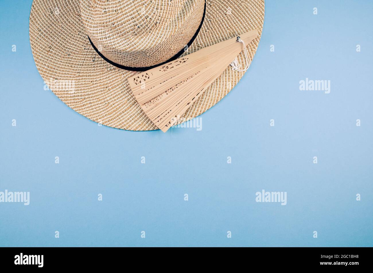 Top view of a straw hat with black ribbon and isolated on blue ...