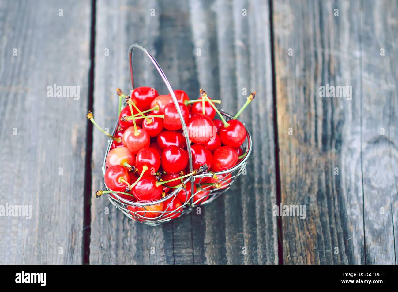 Cherry in small metal basket on wooden surface. Ripe fresh organic ...