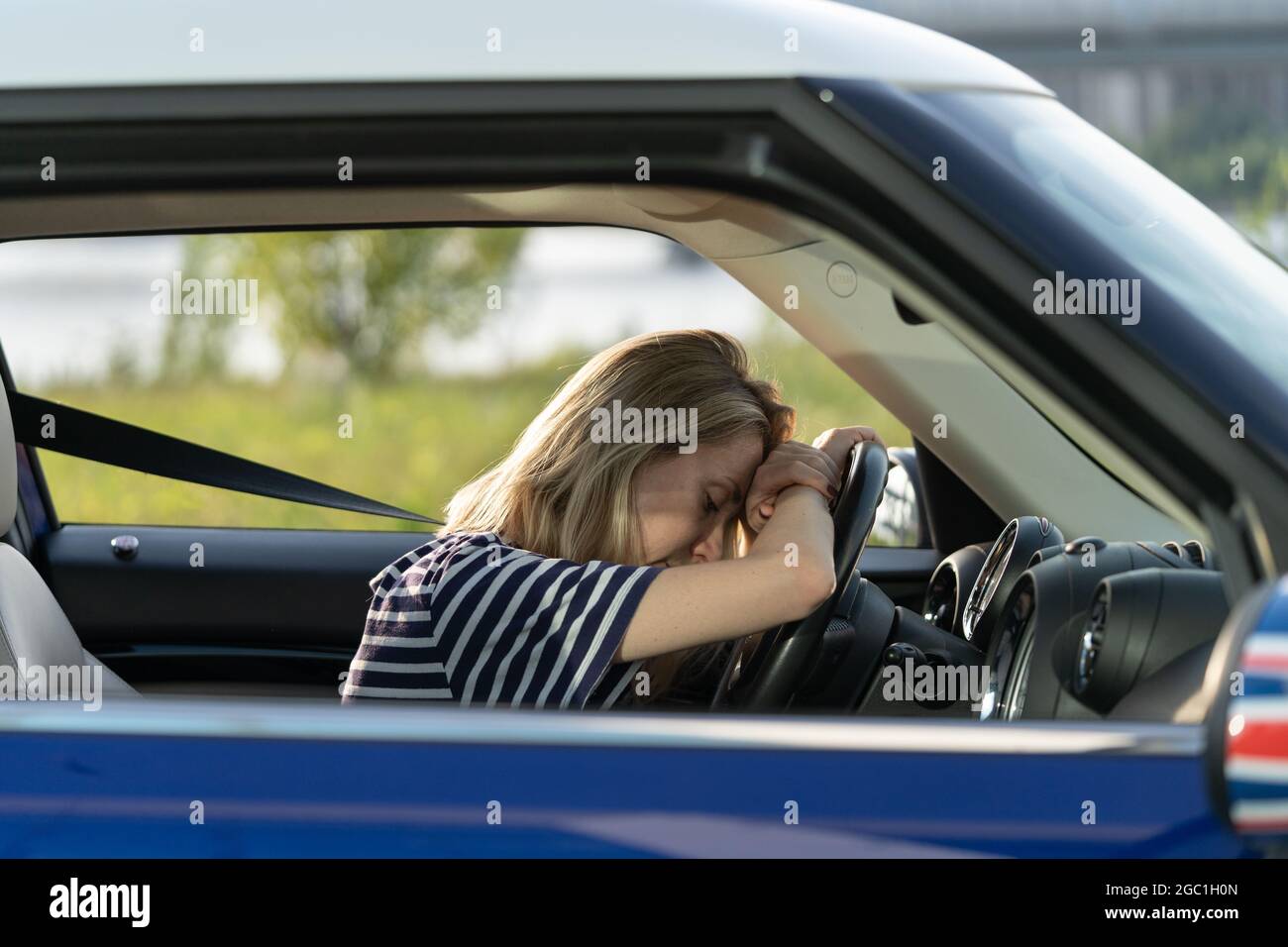 Tired woman lean on steering wheel in car driving. Unhappy sleepy ...