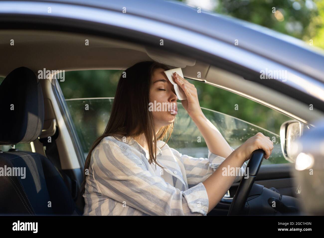 Woman driver being hot during heat wave in car, suffering from hot ...