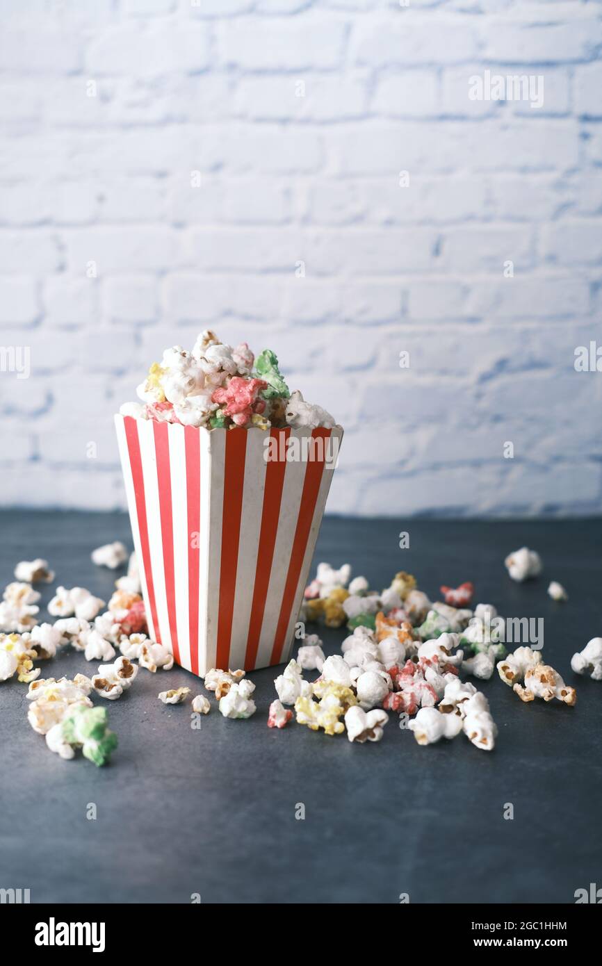 popcorn spilling from a container on a table Stock Photo - Alamy