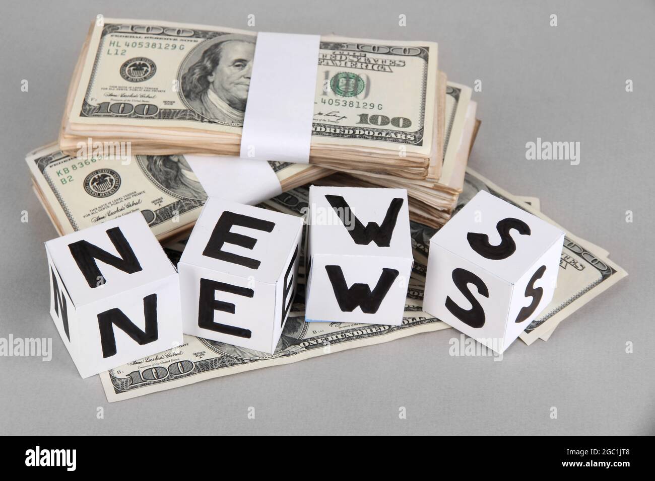 White paper cubes labeled "News" with money on grey background Stock ...