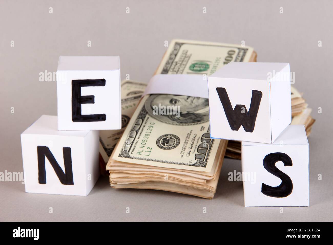 White paper cubes labeled "News" with money on grey background Stock ...
