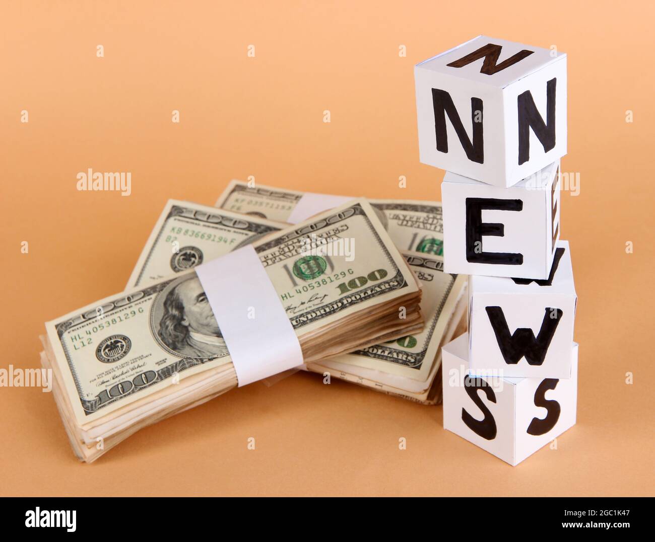 White paper cubes labeled "News" with money on beige background Stock ...