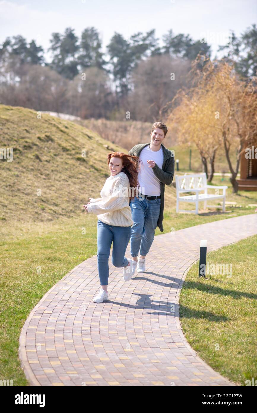 Woman and man running in playful mood in nature Stock Photo - Alamy