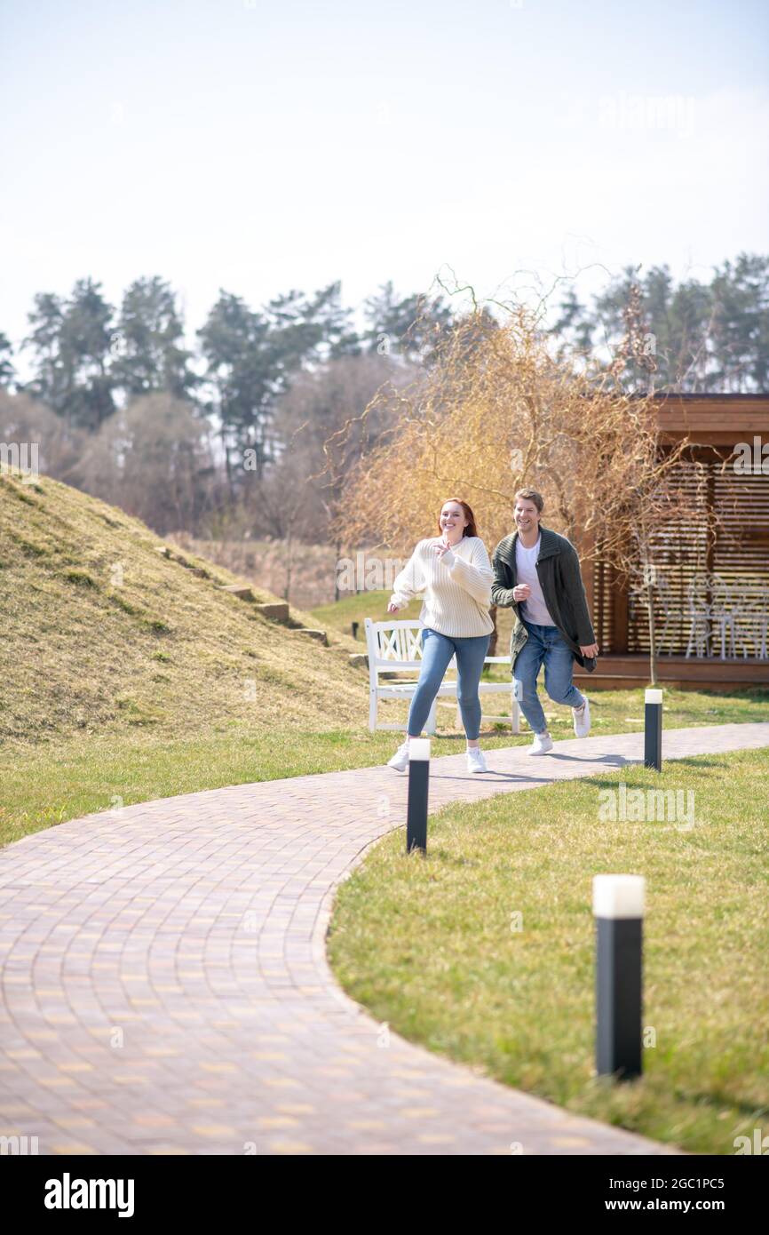 Woman and man running along path outside city Stock Photo - Alamy