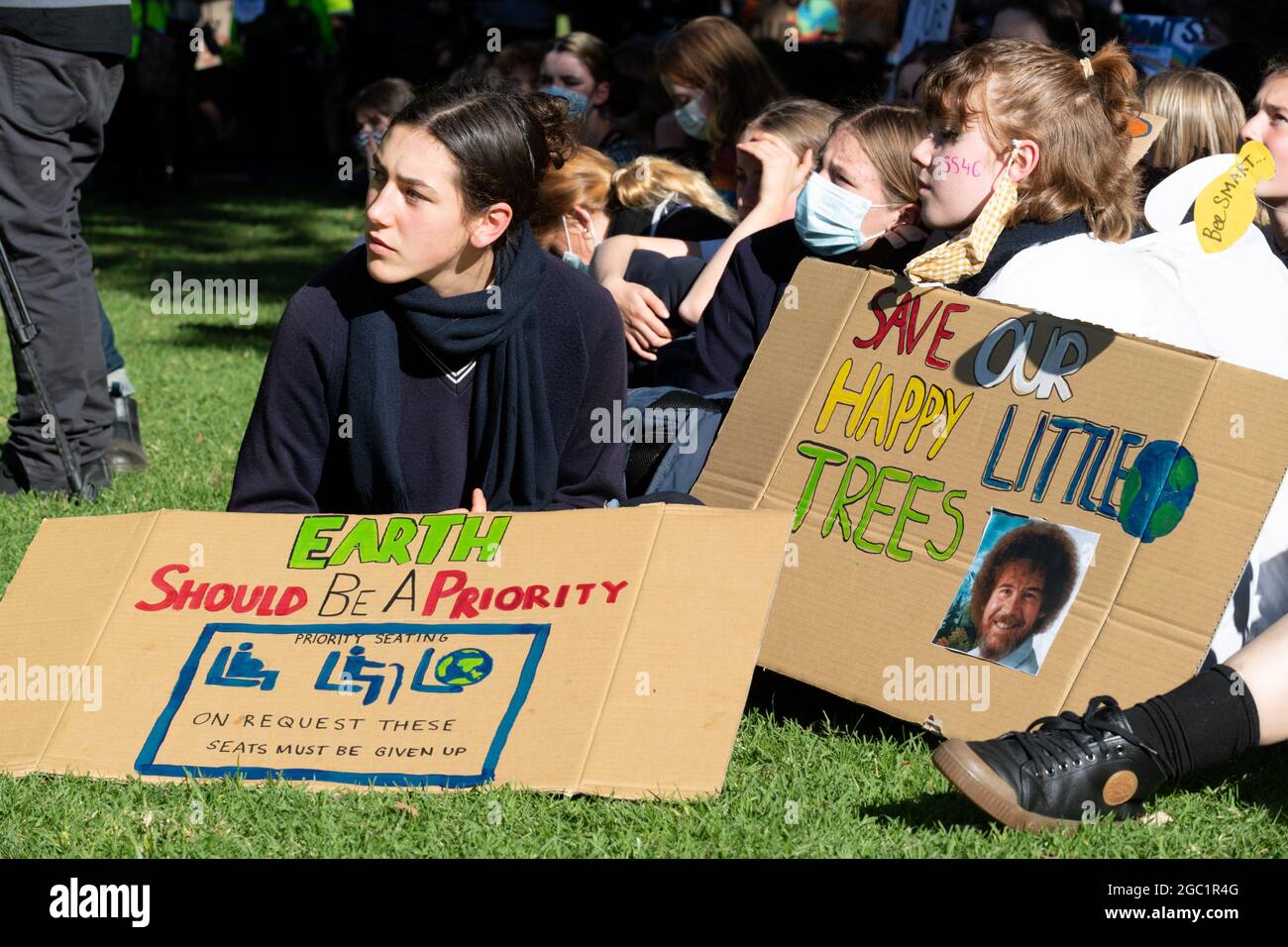 School students sit with their protest signs during a rally that ...