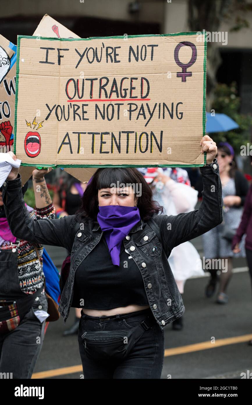 A woman with a sign calling for outrage during a rally and march of ...