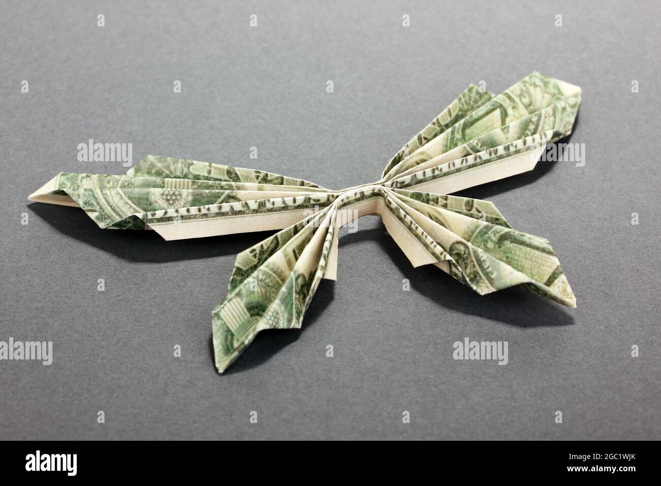 Dollar folded into butterfly on grey background Stock Photo - Alamy