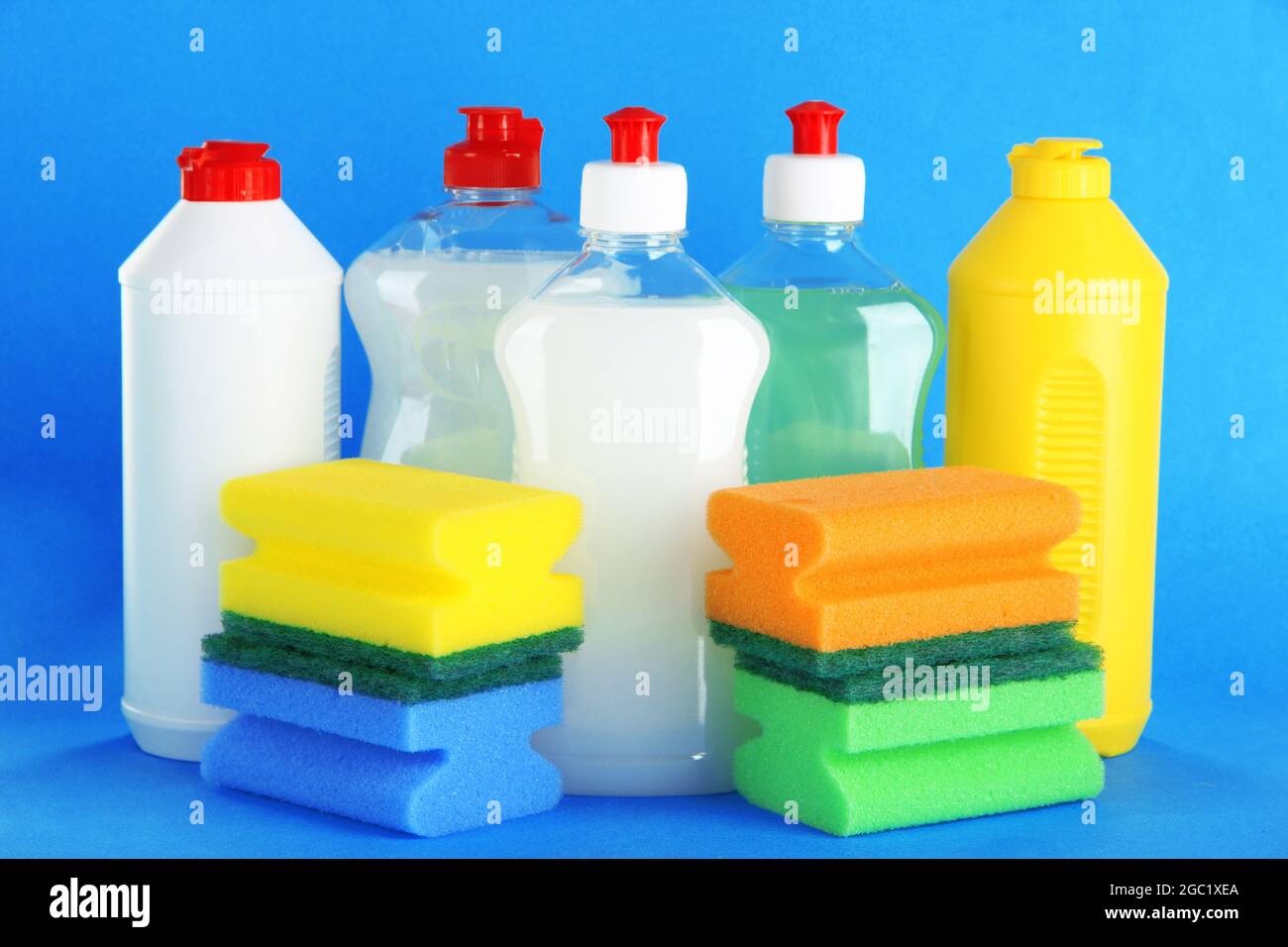 Bottles of dishwashing liquid and sponges on color background Stock ...