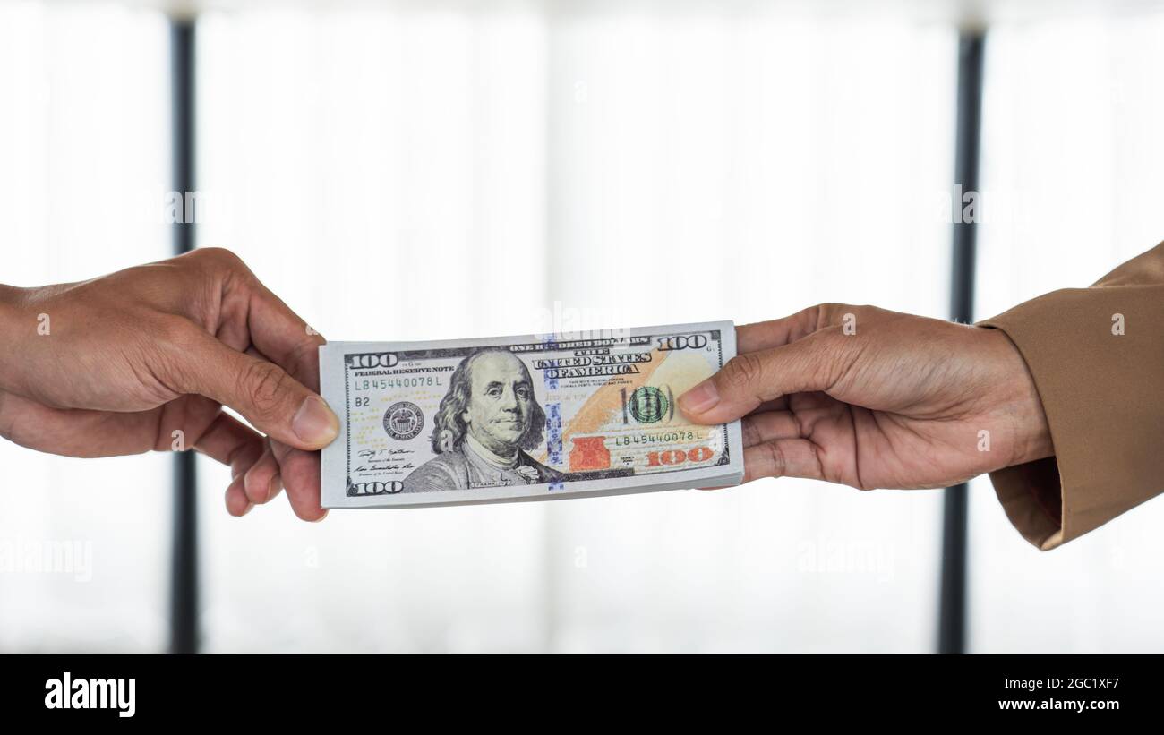 two hands passing bills making agreement to initiate the new business ...