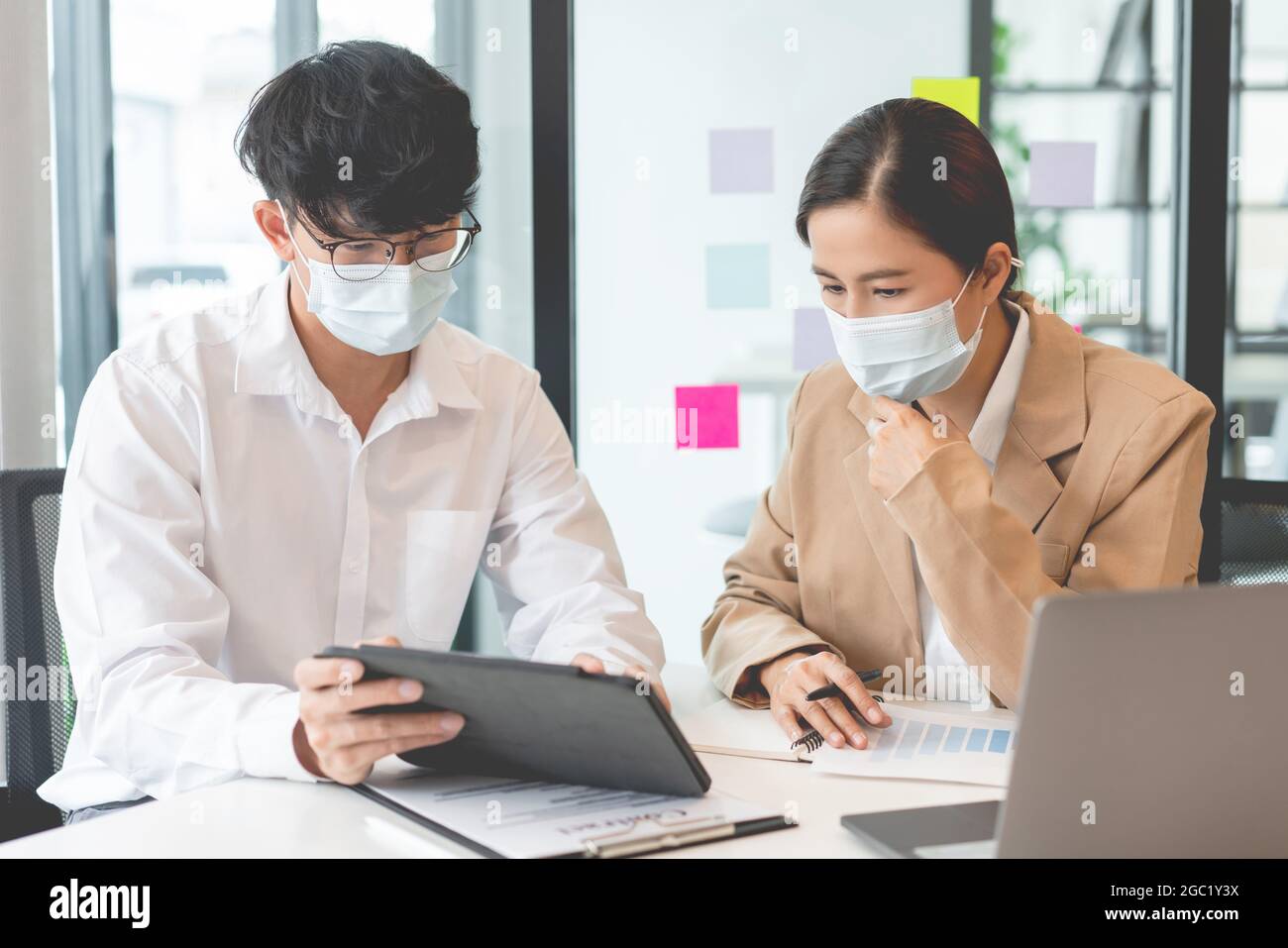 two coworkers helping each other to revise the contract before signing ...